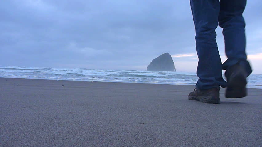 Man Walking Away On Sandy Beach To The Pacific Ocean In Oregons