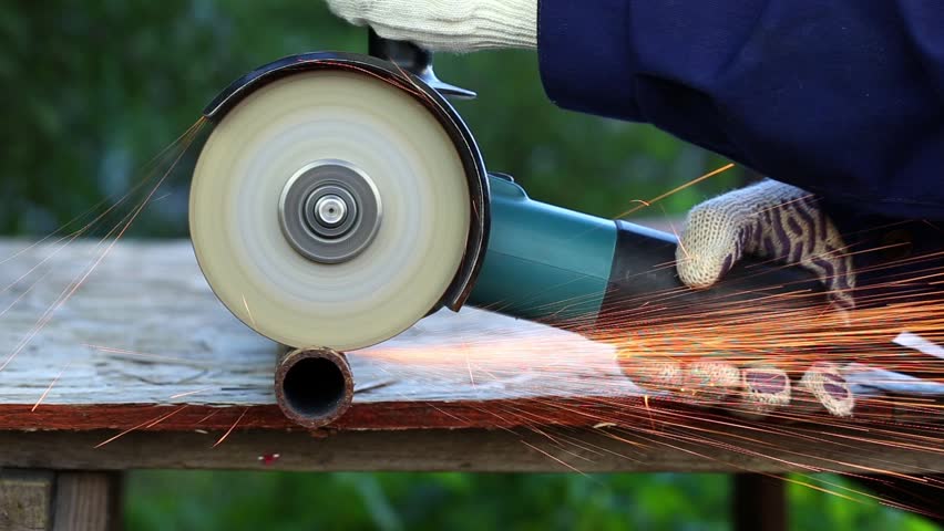 Worker In Gloves Cutting A Metal Pipe In Two Pieces With Angle Grinder ...