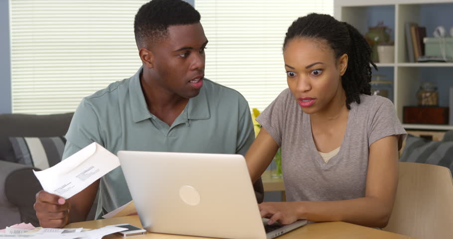 Worried Young African American Couple Looking Through Bills Online ...